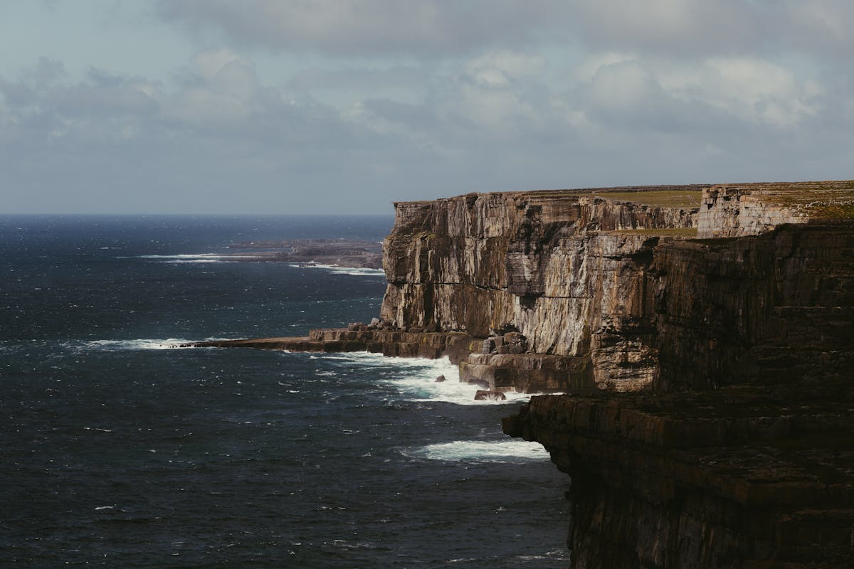 Cliffs of Moher rising from the Atlantic Ocean with waves crashing below