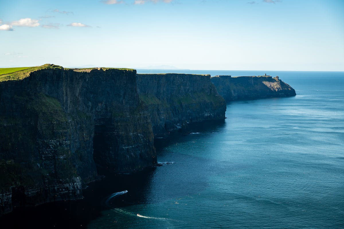 Cliffs of Moher coastline stretching along the Atlantic Ocean on a sunny day