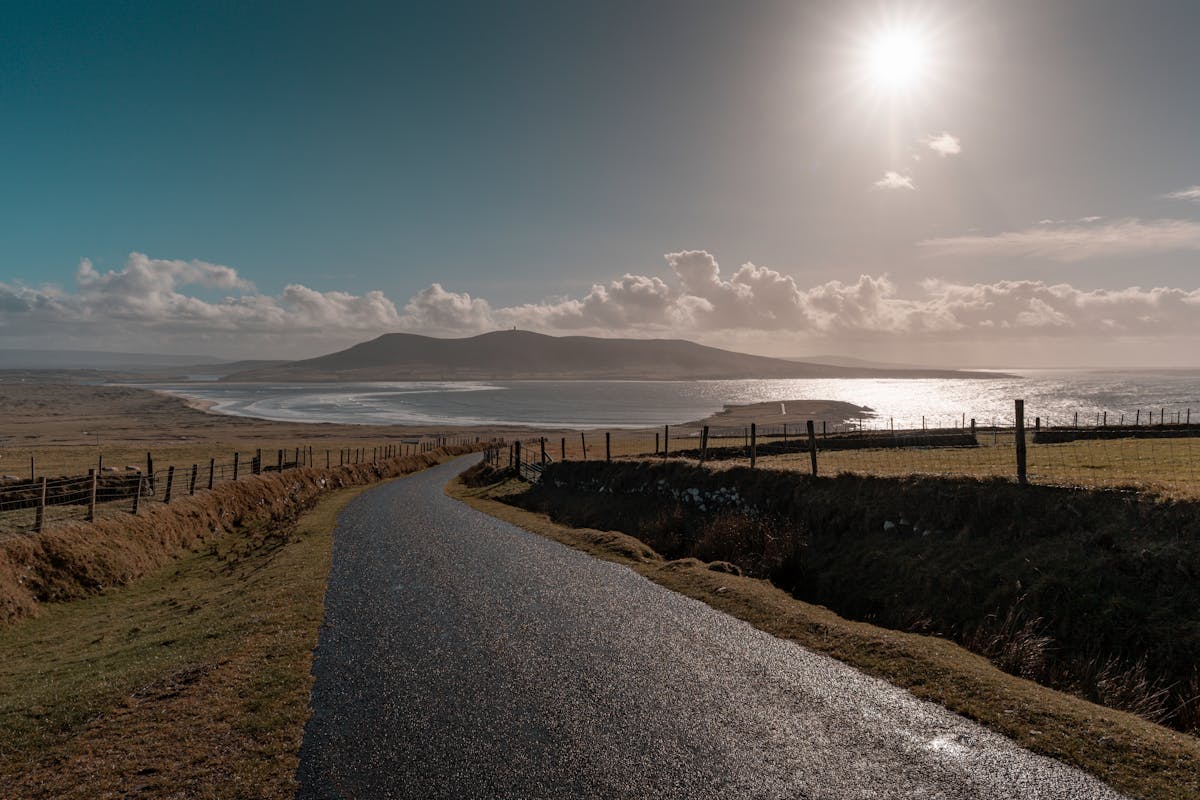 Picturesque coastal road in Ireland with rolling green hills and ocean views