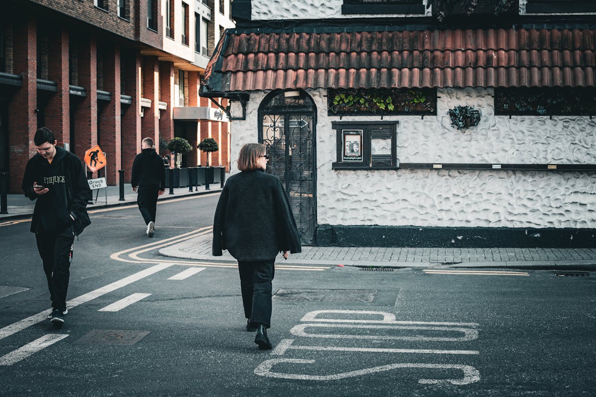Candid street scene with people walking past textured wall in Dublin Ireland