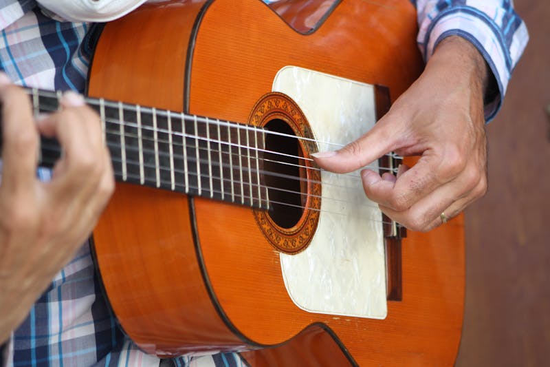 Close-up of a flamenco guitarists hands strumming a wooden guitar in Spain