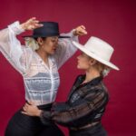 Two flamenco dancers in traditional red dresses posing dramatically