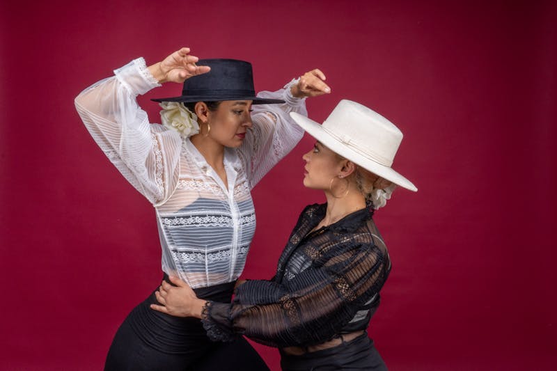 Two flamenco dancers in traditional red dresses posing dramatically