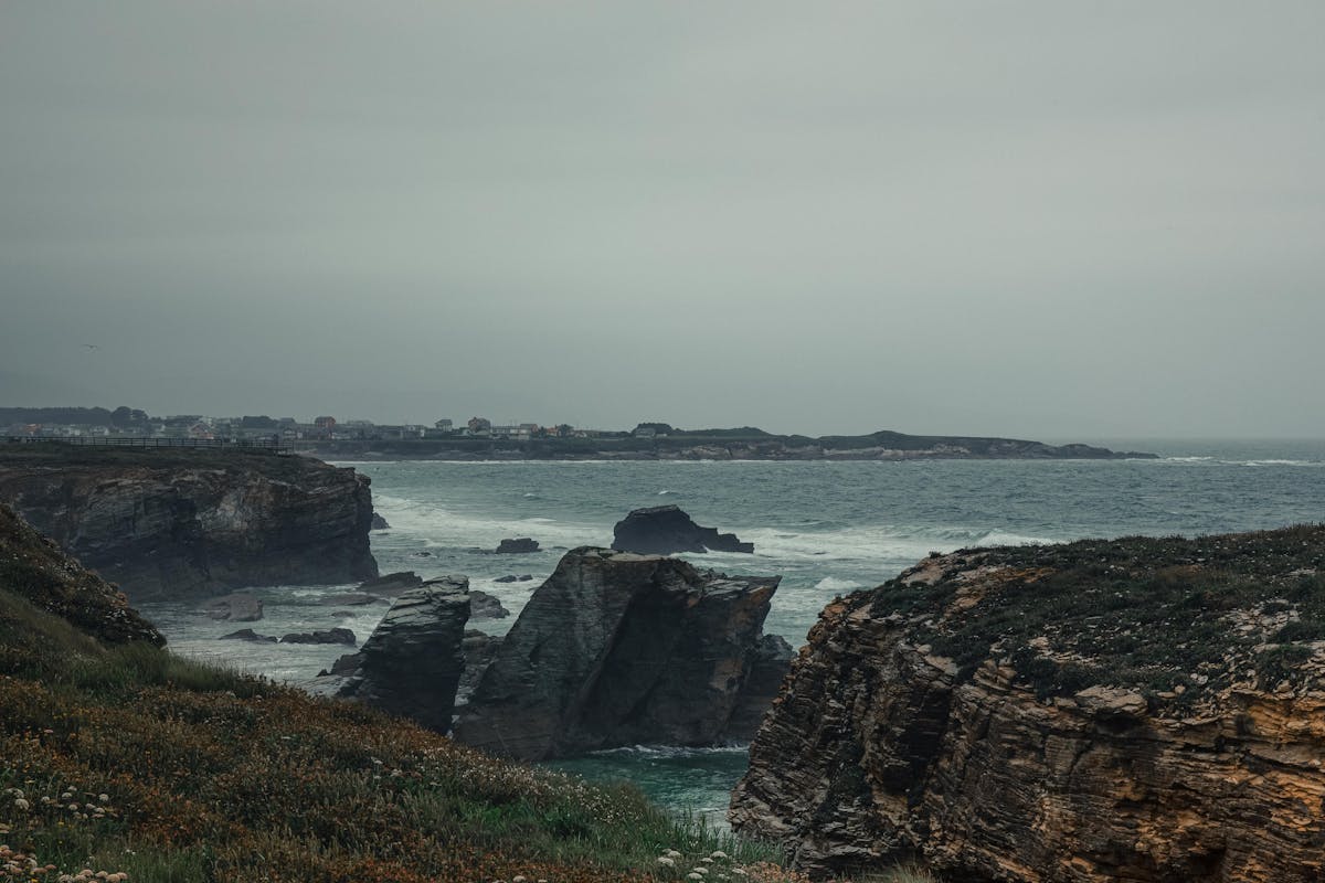 Rocky cliff formations along the Galicia coast with overcast sky