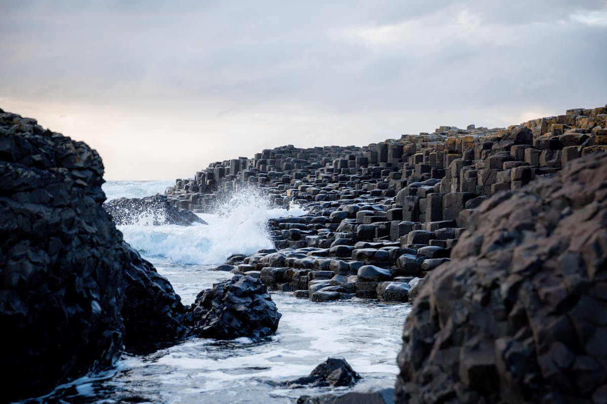 Dramatic basalt columns and crashing waves at Giant Causeway Northern Ireland