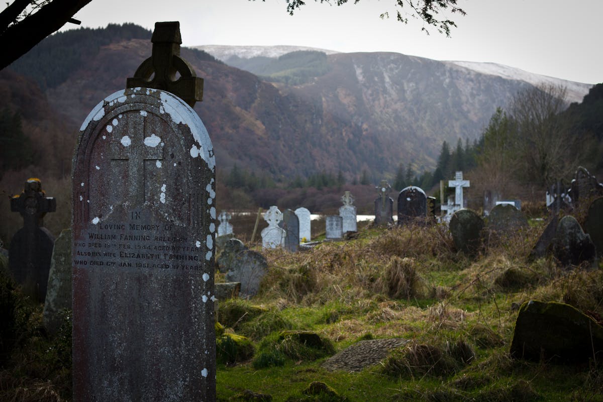 Historic Celtic cemetery in Glendalough surrounded by mountains and trees
