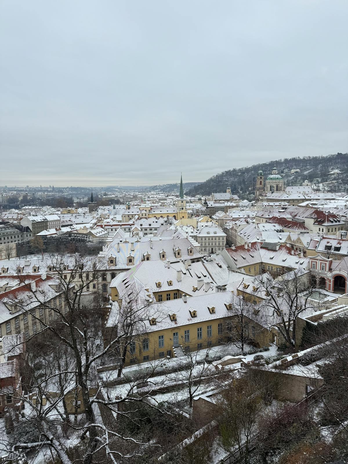 Aerial view of snow-covered historic Prague cityscape during winter