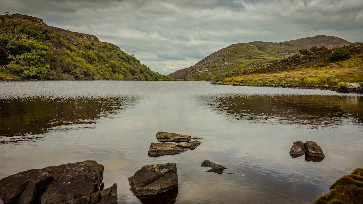 Serene lake surrounded by lush green hills in Killarney National Park Ireland