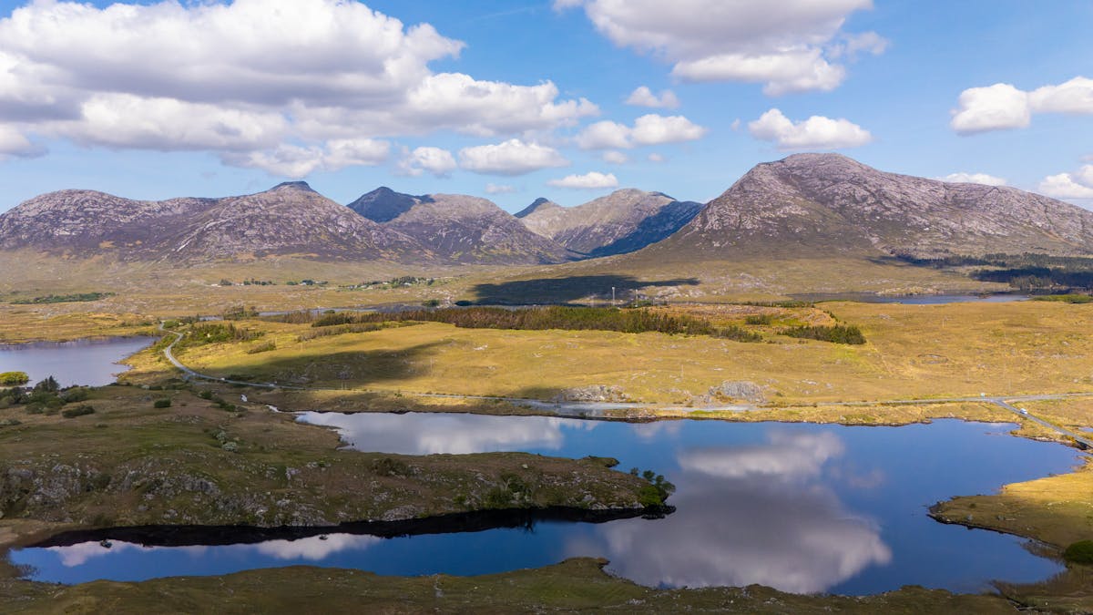 Connemara mountains reflecting in tranquil lake water in Ireland