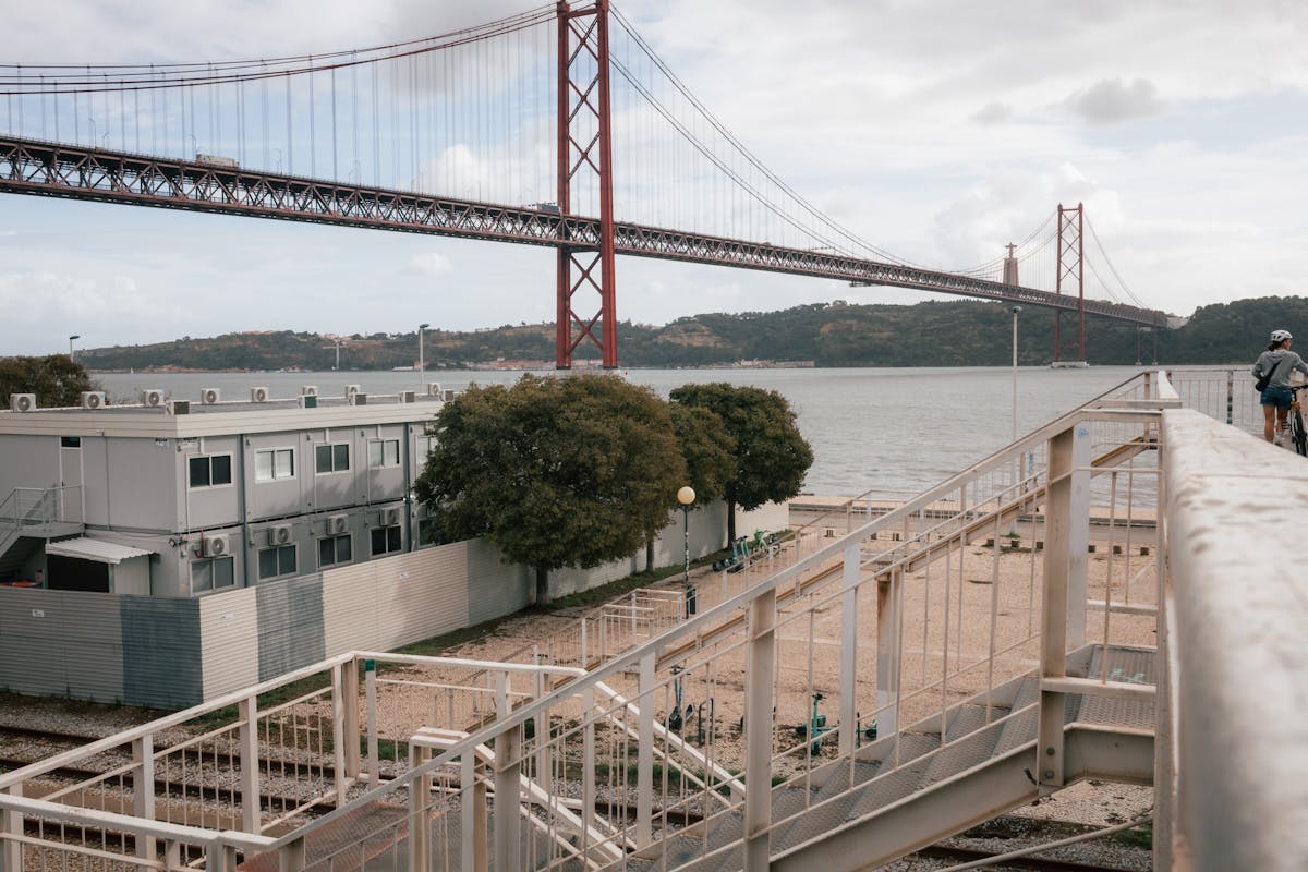 The 25 de Abril Bridge illuminated during sunset with Lisbon skyline