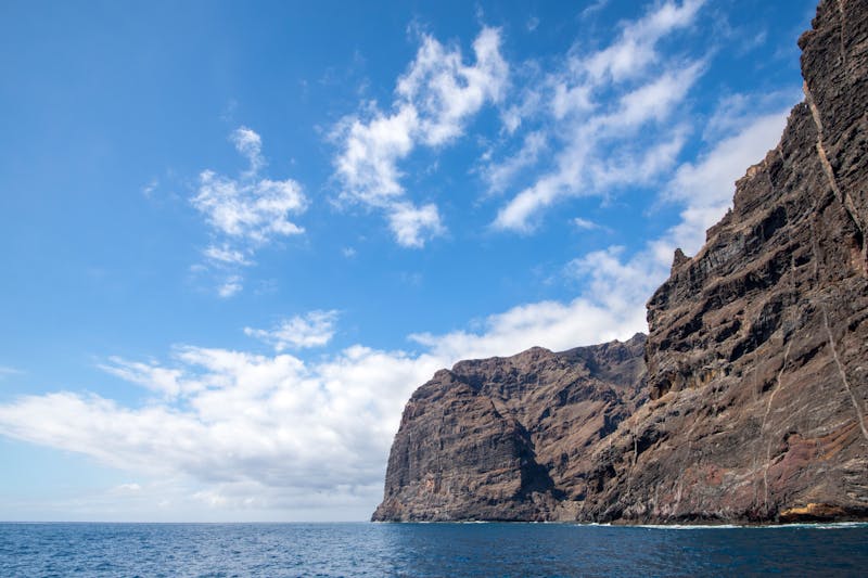 Majestic cliffs of Los Gigantes towering above the ocean in Tenerife under a blue sky