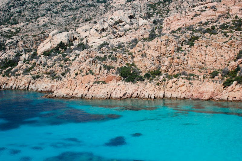 Rocky cliffs and crystal-clear turquoise waters along the Sardinian coastline