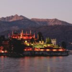 Isola Bella island silhouetted against a warm sunset with mountain backdrop on Lake Maggiore