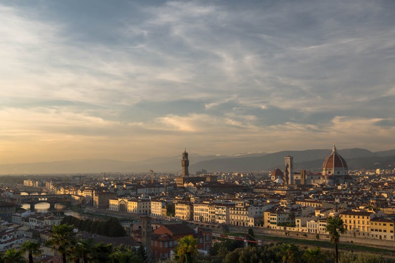 Panoramic view of Florence Italy at sunset showing the Duomo dome and red rooftops