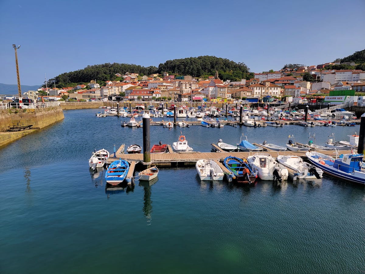 Colorful boats and charming village buildings at Muros harbor in Galicia Spain