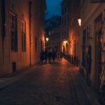 Cobblestone street in Prague Old Town lit up at night with warm glowing lights