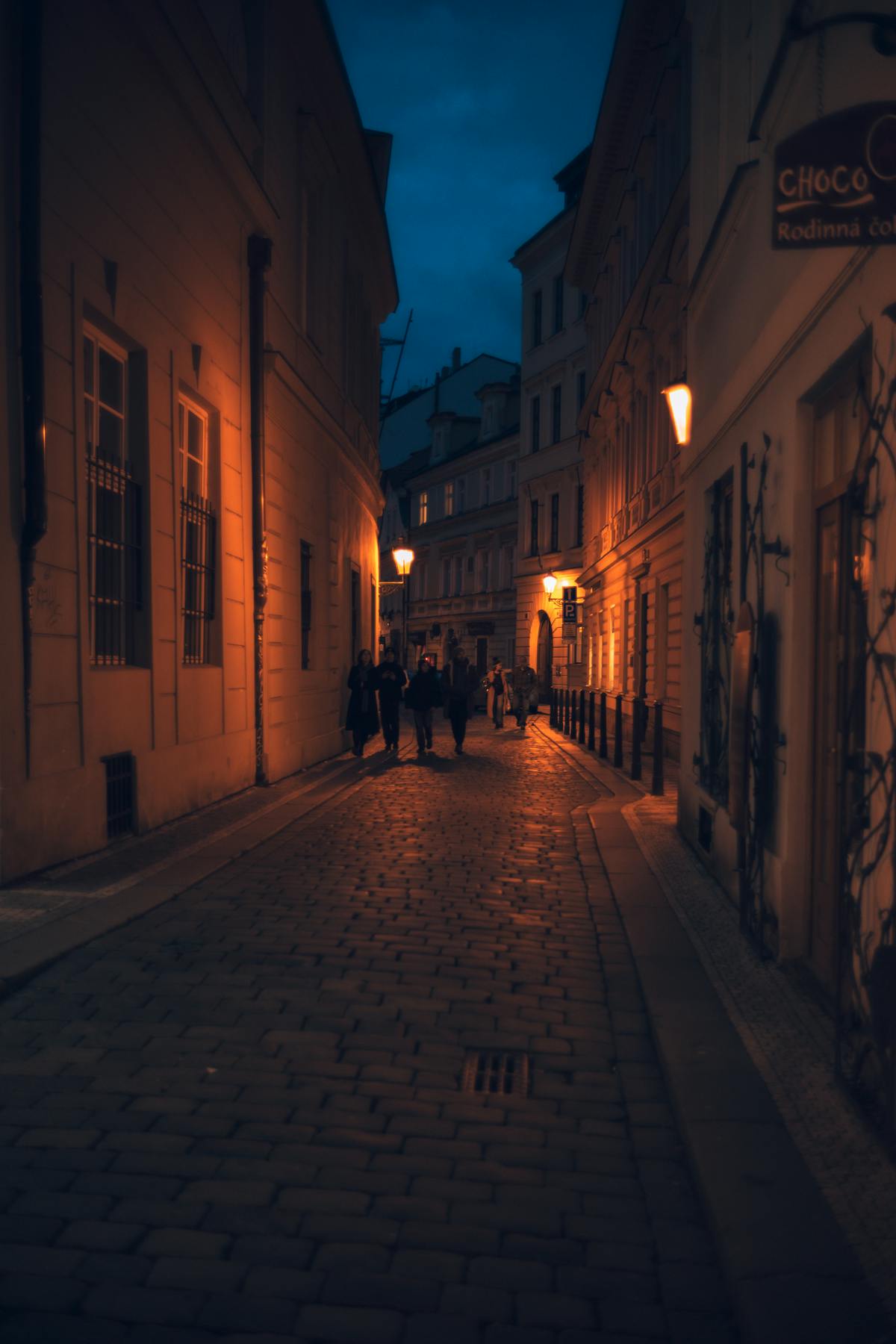 Cobblestone street in Prague Old Town lit up at night with warm glowing lights
