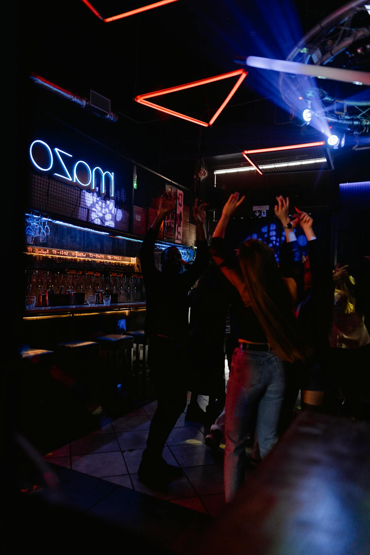 People dancing in a nightclub under colorful neon lights