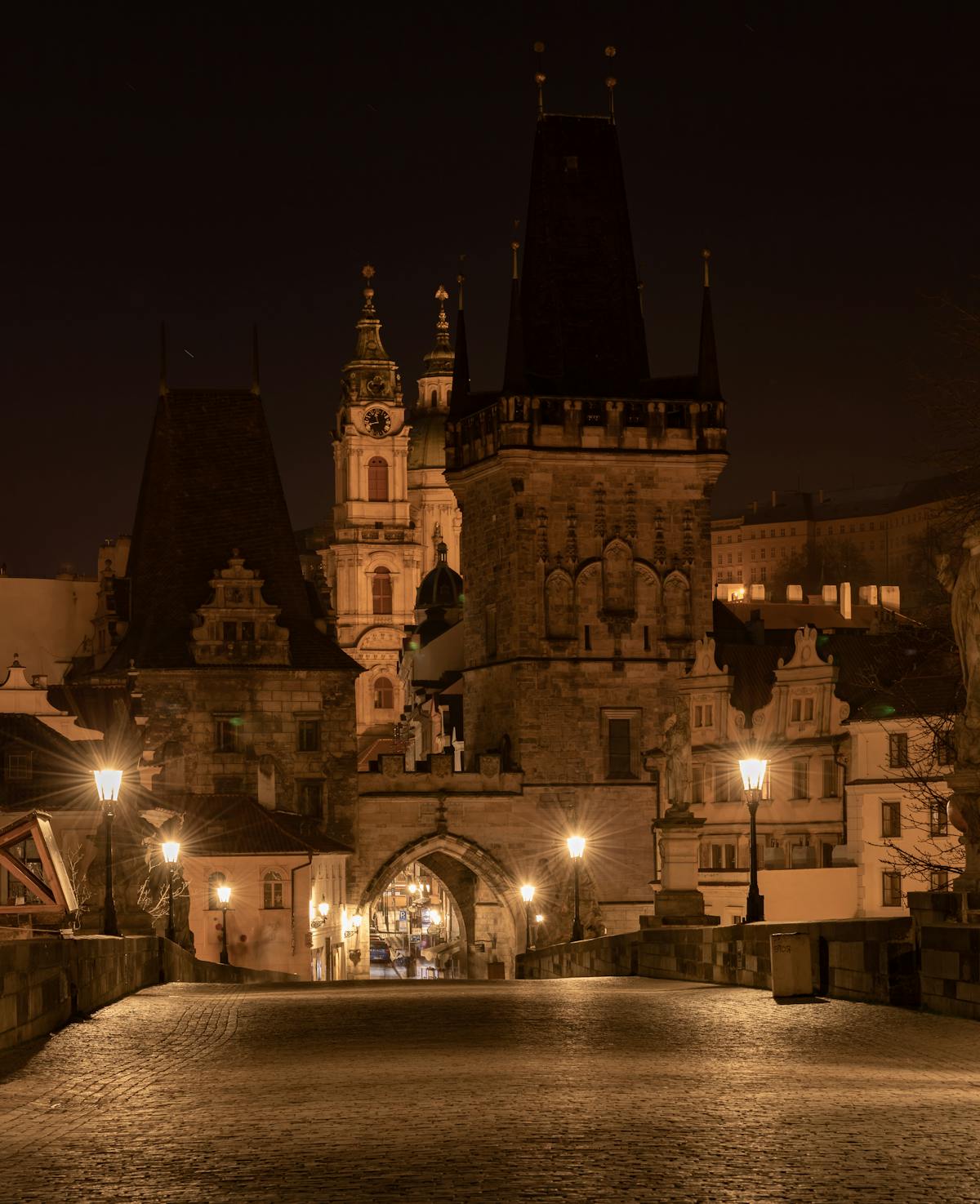Charles Bridge and Prague Old Town illuminated at night with reflections in the river