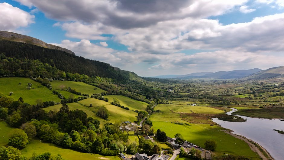 Green Irish valley with lakes and low clouds over mountains