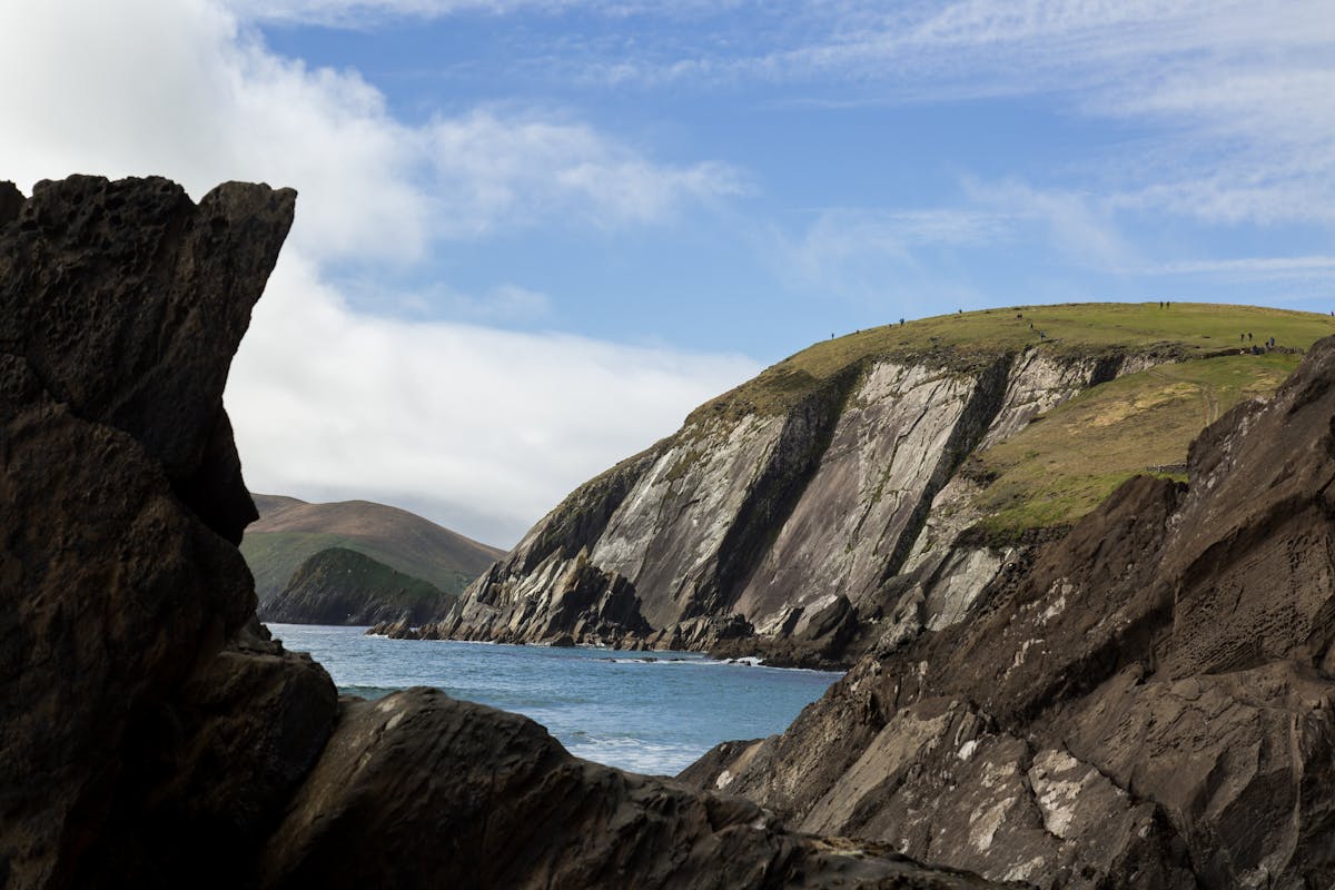Rugged cliffs along Dingle Peninsula Ireland under a blue sky