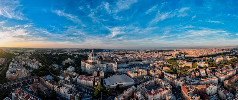 Panoramic aerial view of St Peters Basilica and the Vatican City skyline at sunset