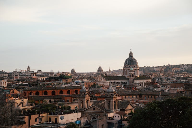 Rome skyline featuring historic church domes and architecture at dusk