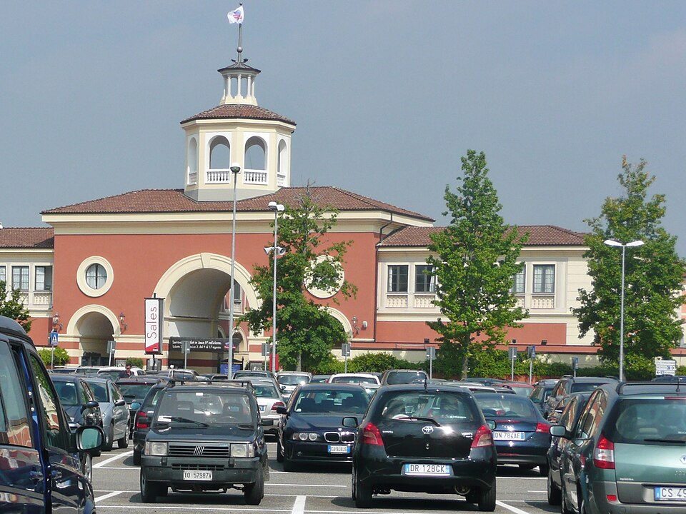 Walkway between designer stores at Serravalle Designer Outlet showing the village-style architecture