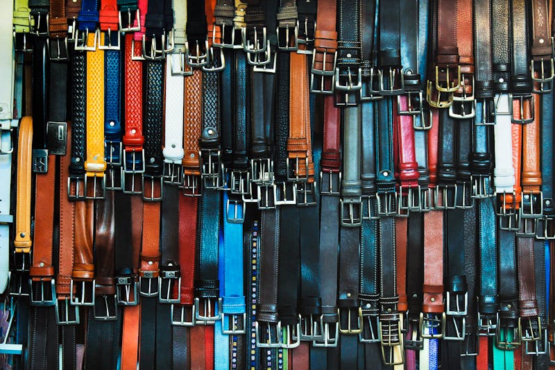 Colorful assortment of leather belts hanging in an Italian shop