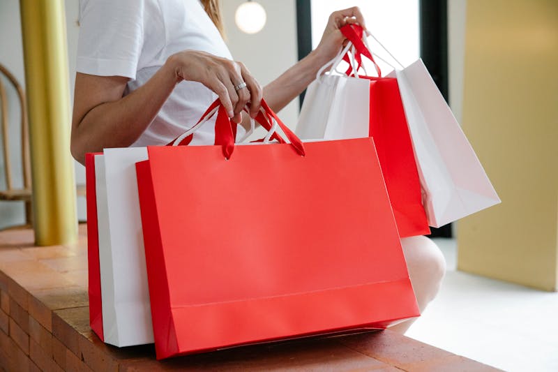 Woman sitting on bench surrounded by shopping bags