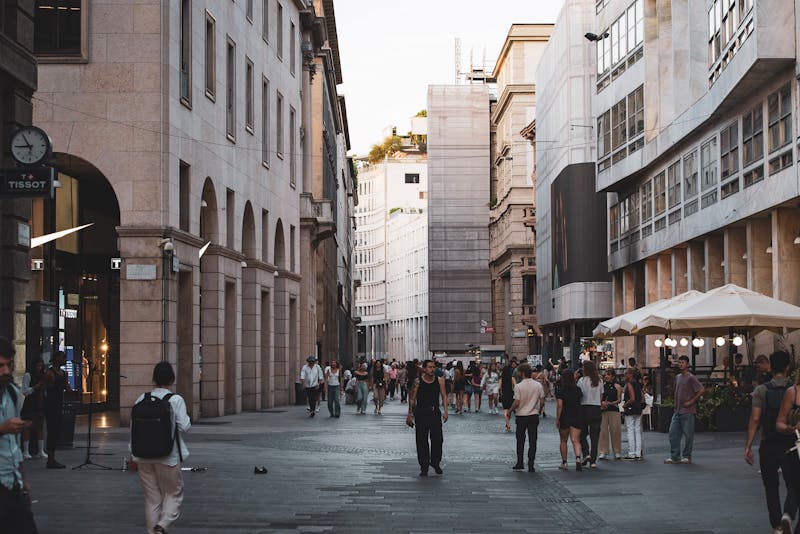 Busy street scene in Milan city center with historic architecture and crowds of people