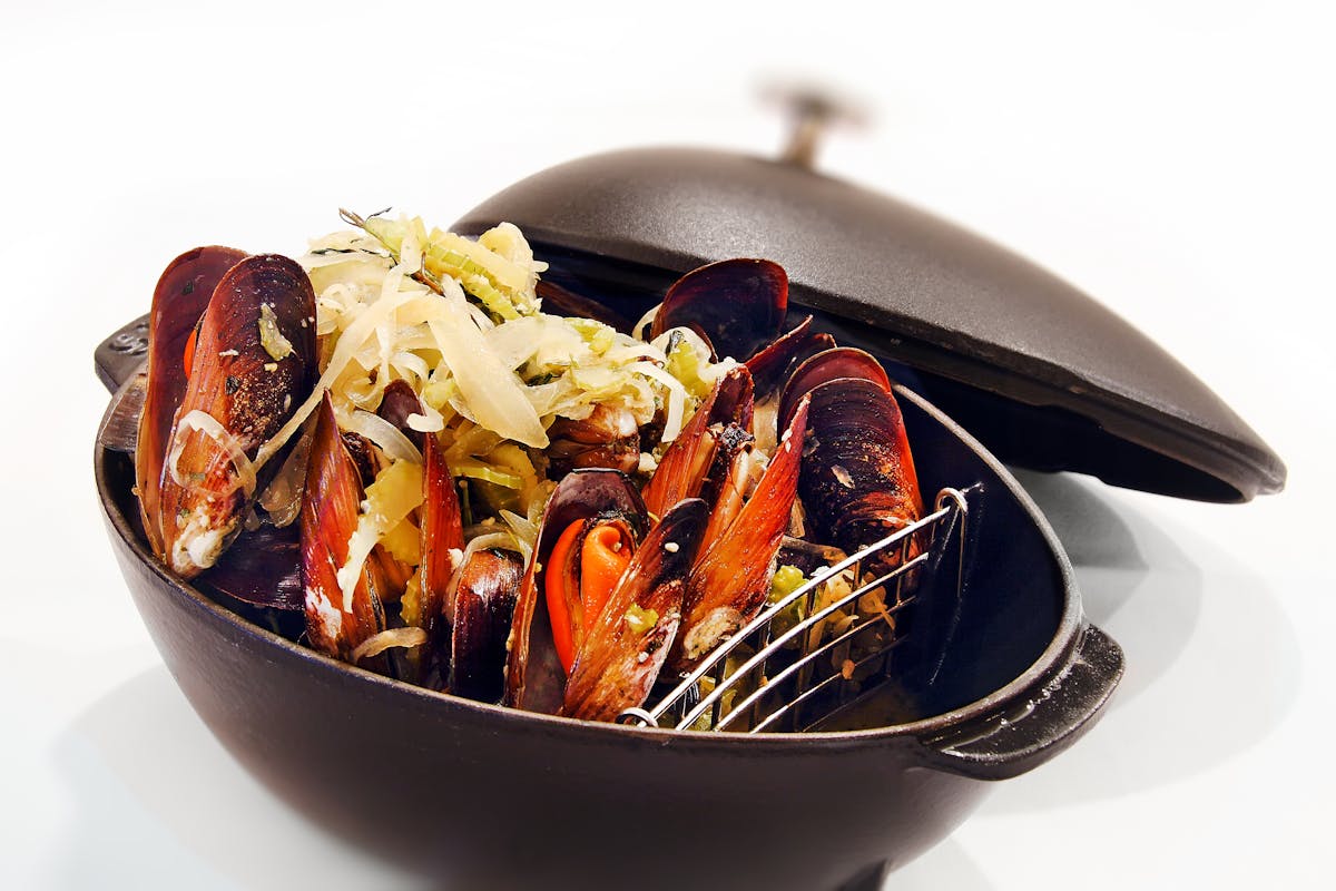 Steamed mussels in a cast iron cooking pot gourmet seafood