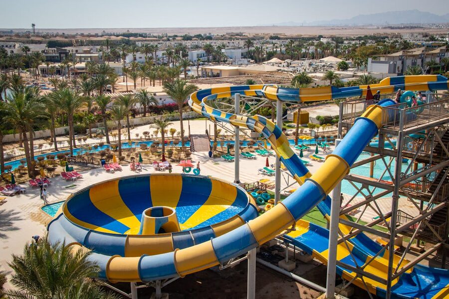 Yellow and blue water slides at a tropical water park under sunny skies