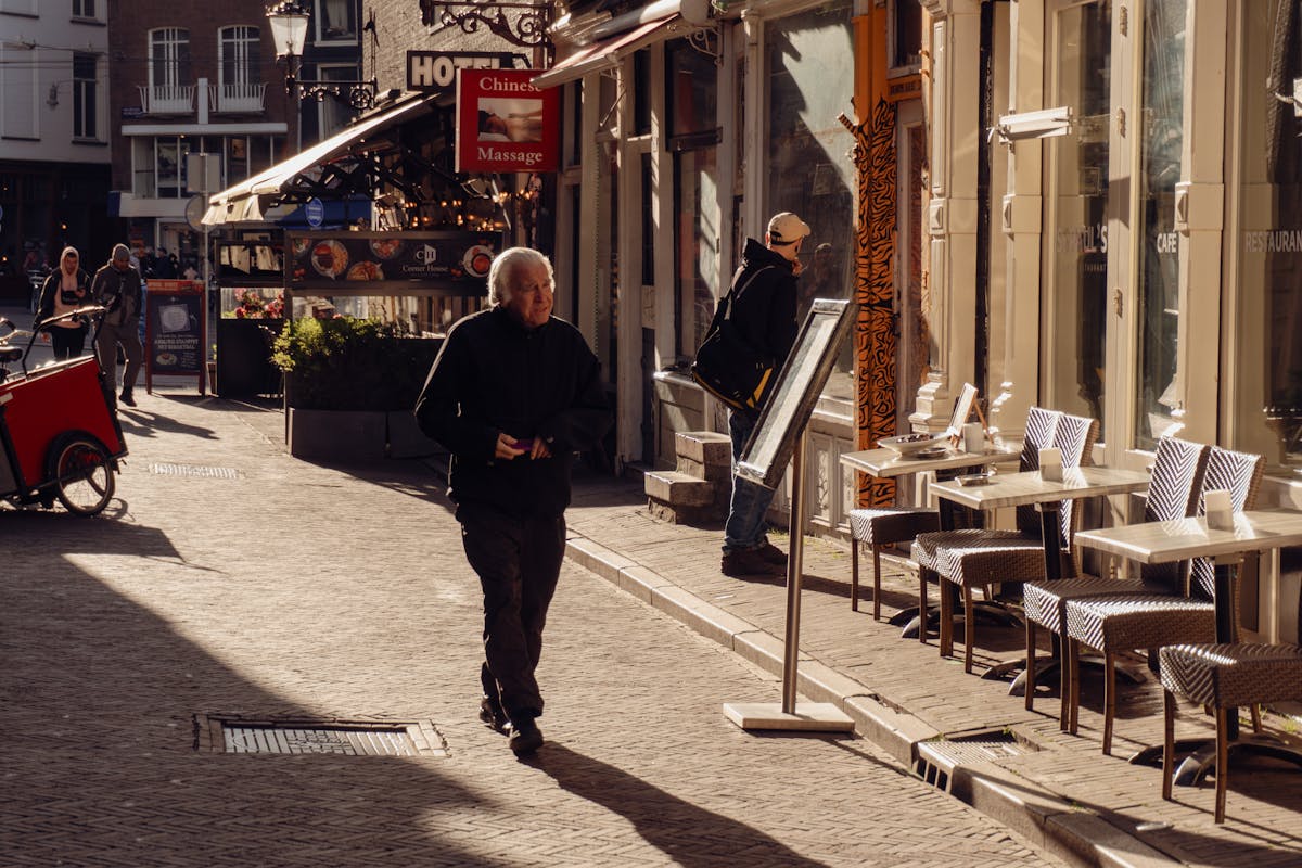 Sunlit Amsterdam street with charming cafes and local shops