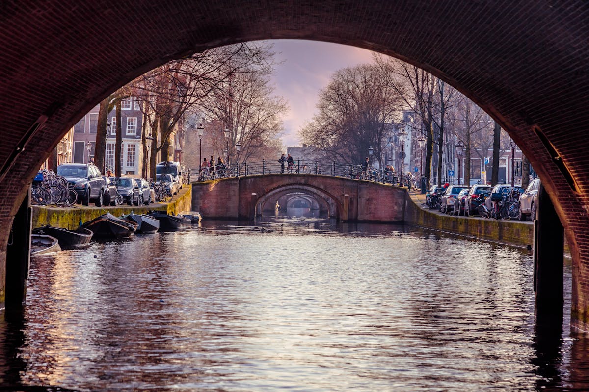 Stunning view of an Amsterdam canal framed by a bridge arch