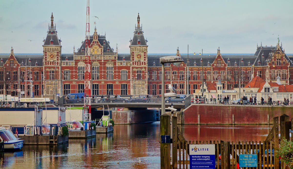 Scenic view of Amsterdam Centraal station and canal with local architecture