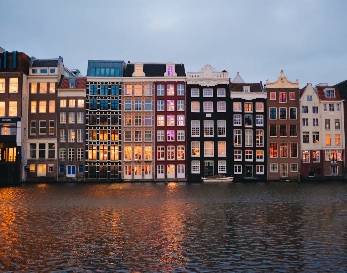 Amsterdam canal houses reflecting on the water at dusk