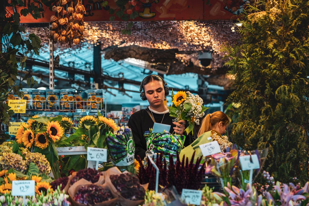 Vibrant flower market in Amsterdam with sunflowers and people shopping