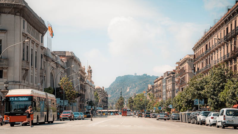 Barcelona urban street scene with classic architecture and Montjuic mountain in background