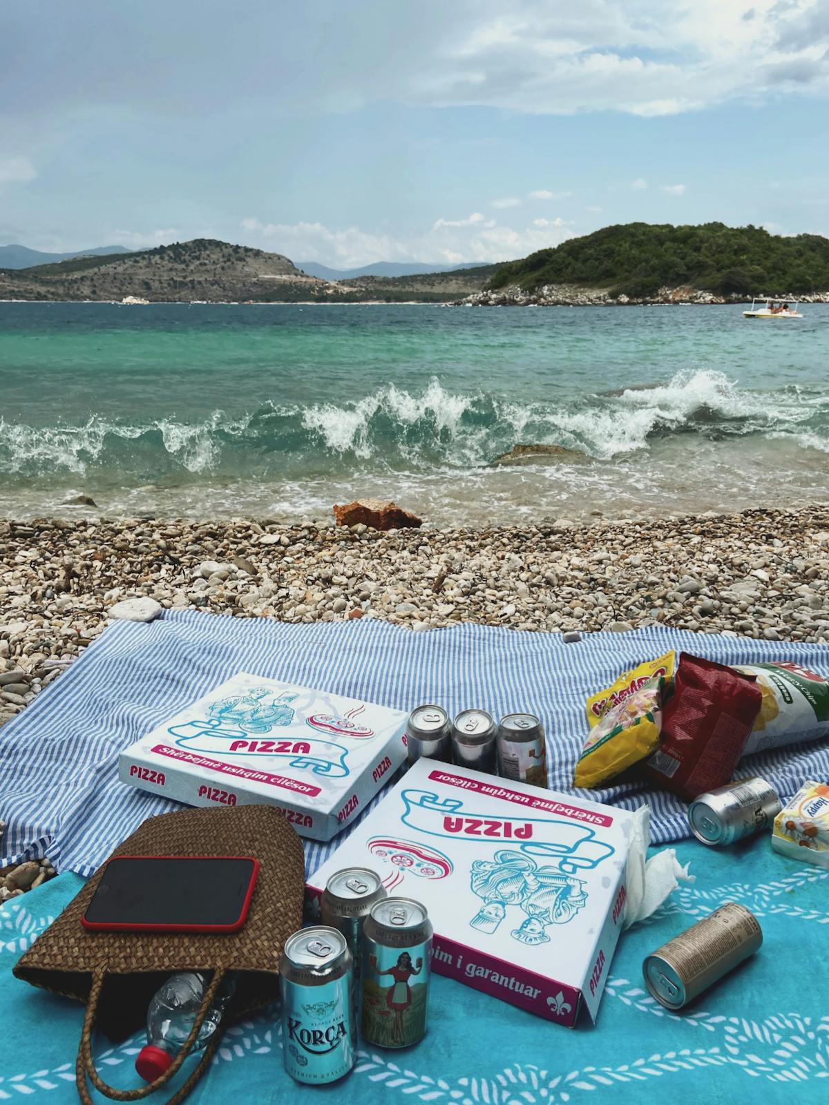 Beach picnic spread with food and drinks on a summer day