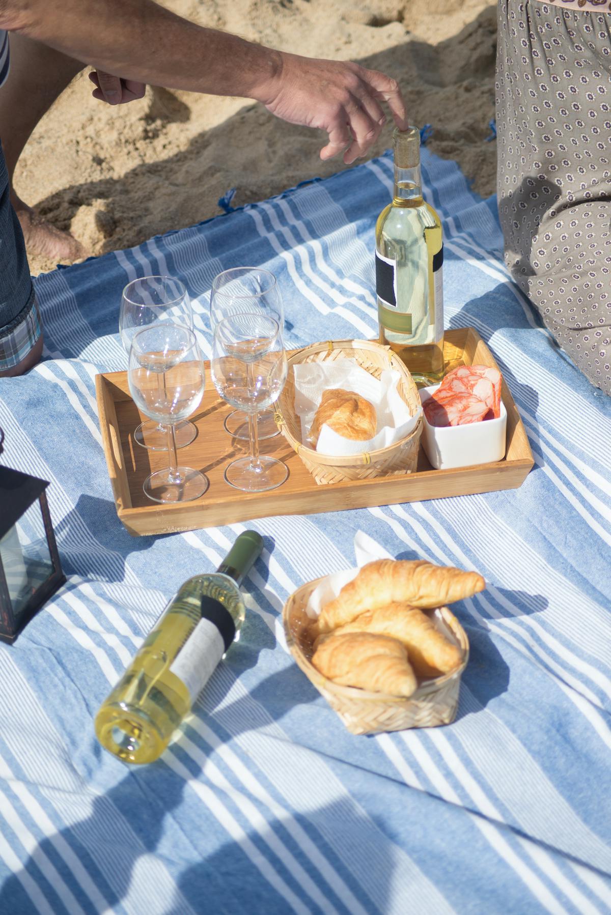 Beach picnic with wine pastries and snacks