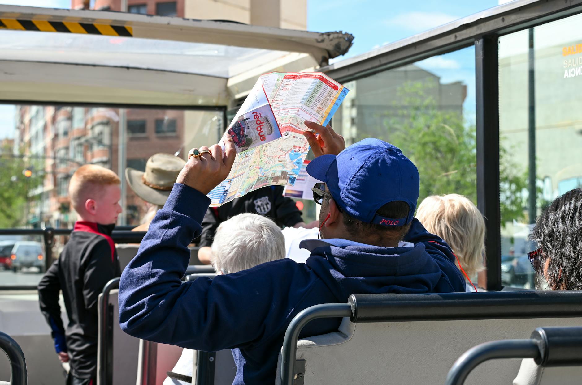Tourists on an open-top bus tour through a European city