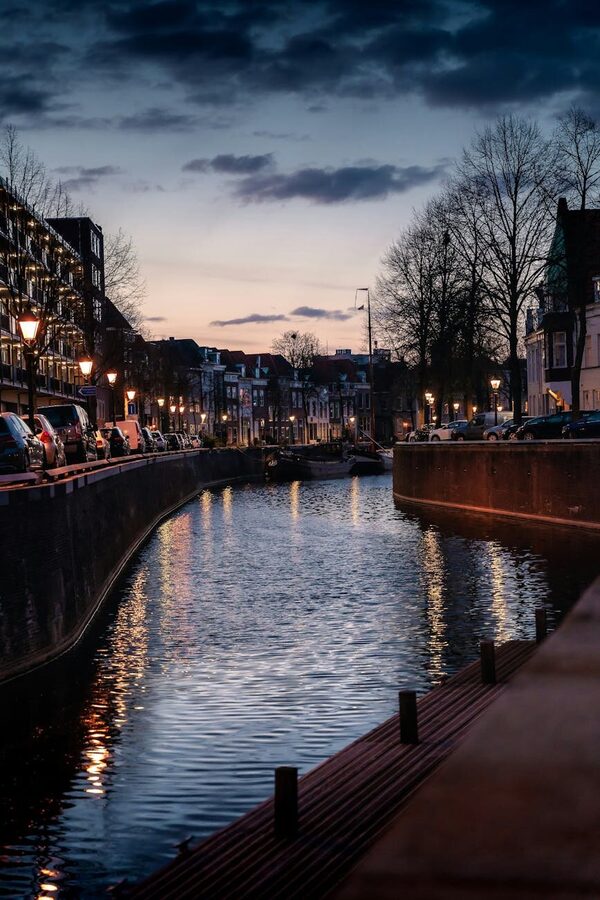 Beautiful canal in Amsterdam during twilight with reflections on water
