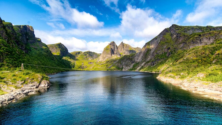 Scenic view of Bergen fjord surrounded by mountains under clear skies