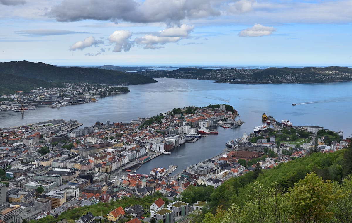 Aerial view of Bergen Norway with colorful buildings and harbor surrounded by fjords