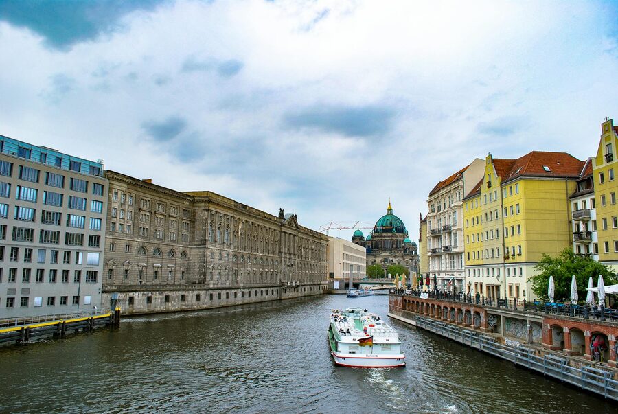 Historic architecture along Berlin riverfront with a tranquil boat