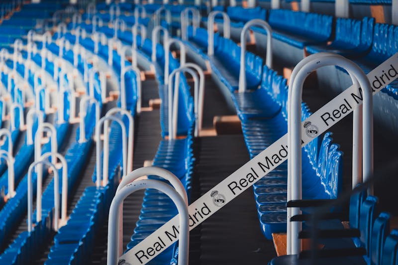 Close-up view of rows of blue stadium seats with Real Madrid branding at Santiago Bernabeu