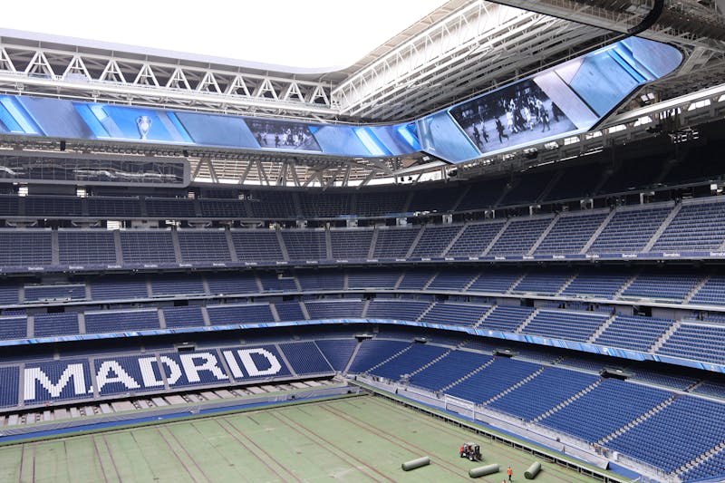 Modern interior of Santiago Bernabeu Stadium showing Real Madrid branding and contemporary architectural design