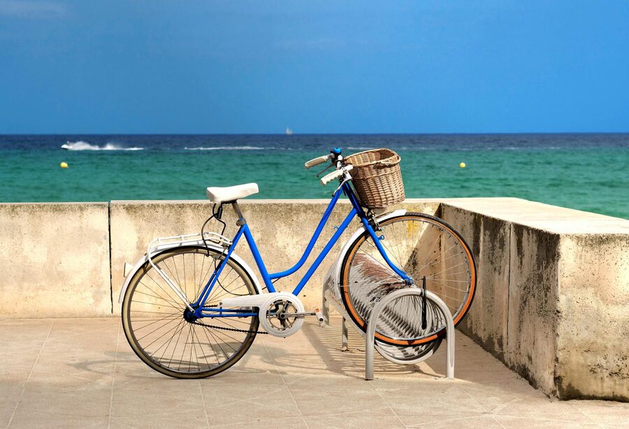 A blue bicycle parked by the seaside in Spain on a sunny day