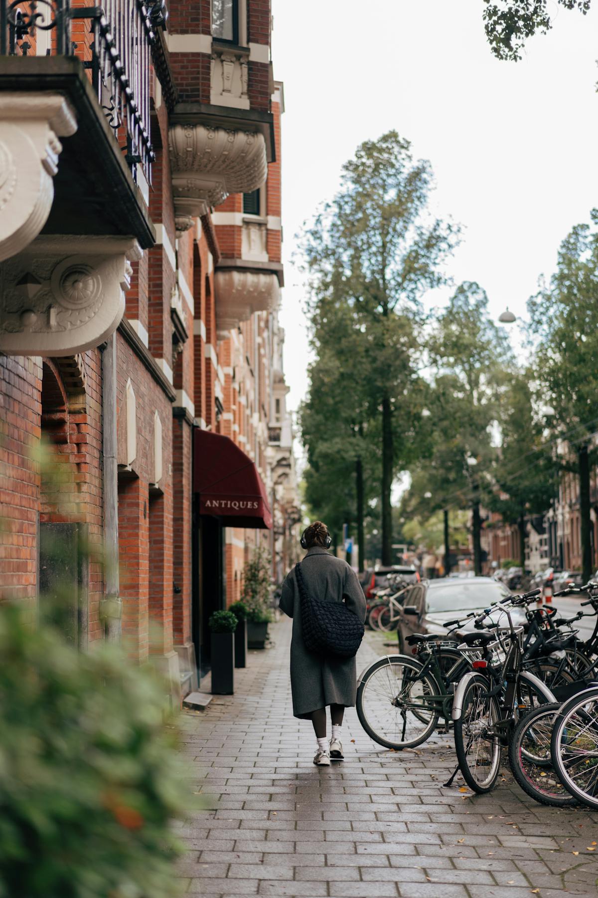 Person walking along a street lined with parked bicycles in Amsterdam